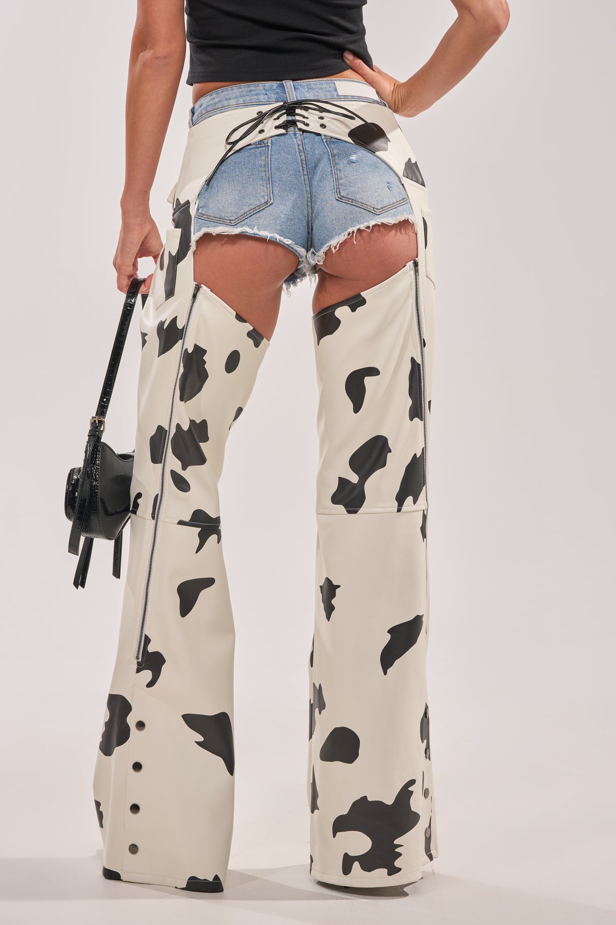 MOO OVER COW PRINT FAUX LEATHER CHAPS – AKIRA